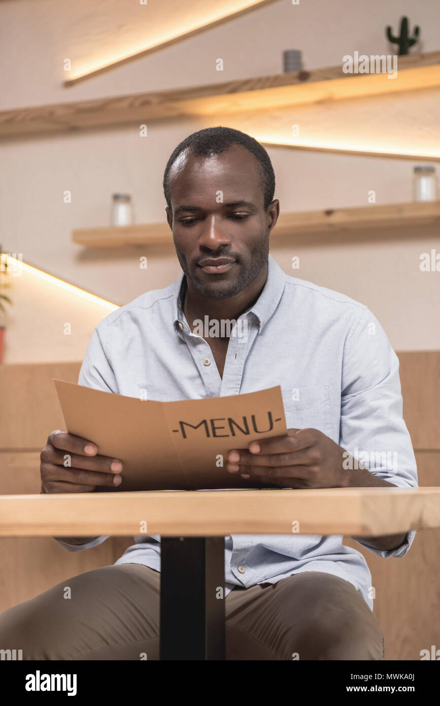 pensive african-american man in cafe looking at menu list Stock Photo ...