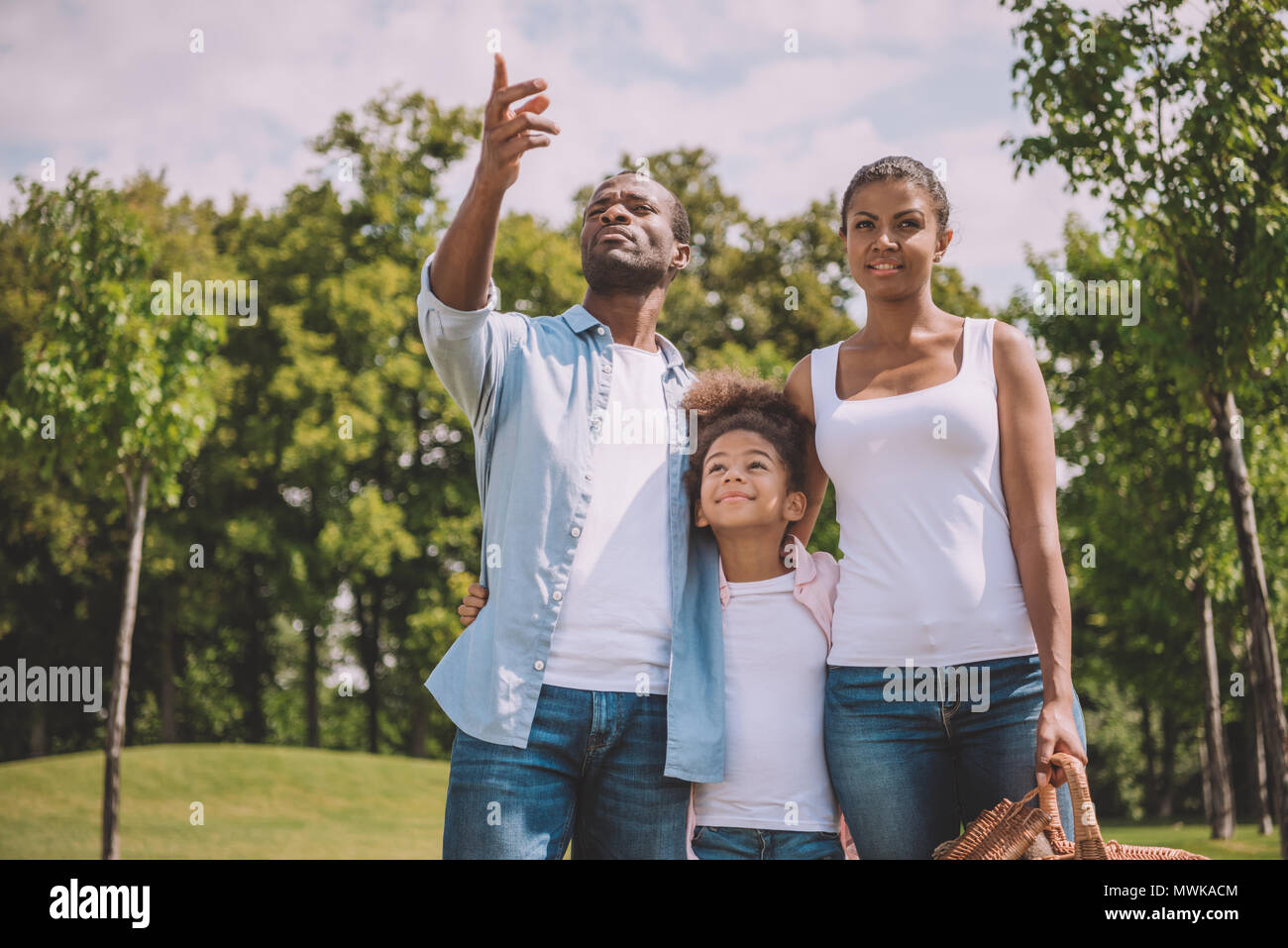 portrait of african american young family hugging each other in park ...