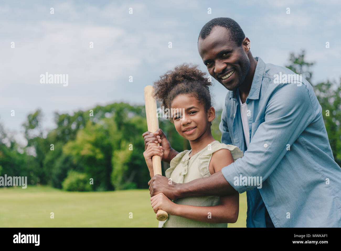 portrait of african american father helping little daughter play ...
