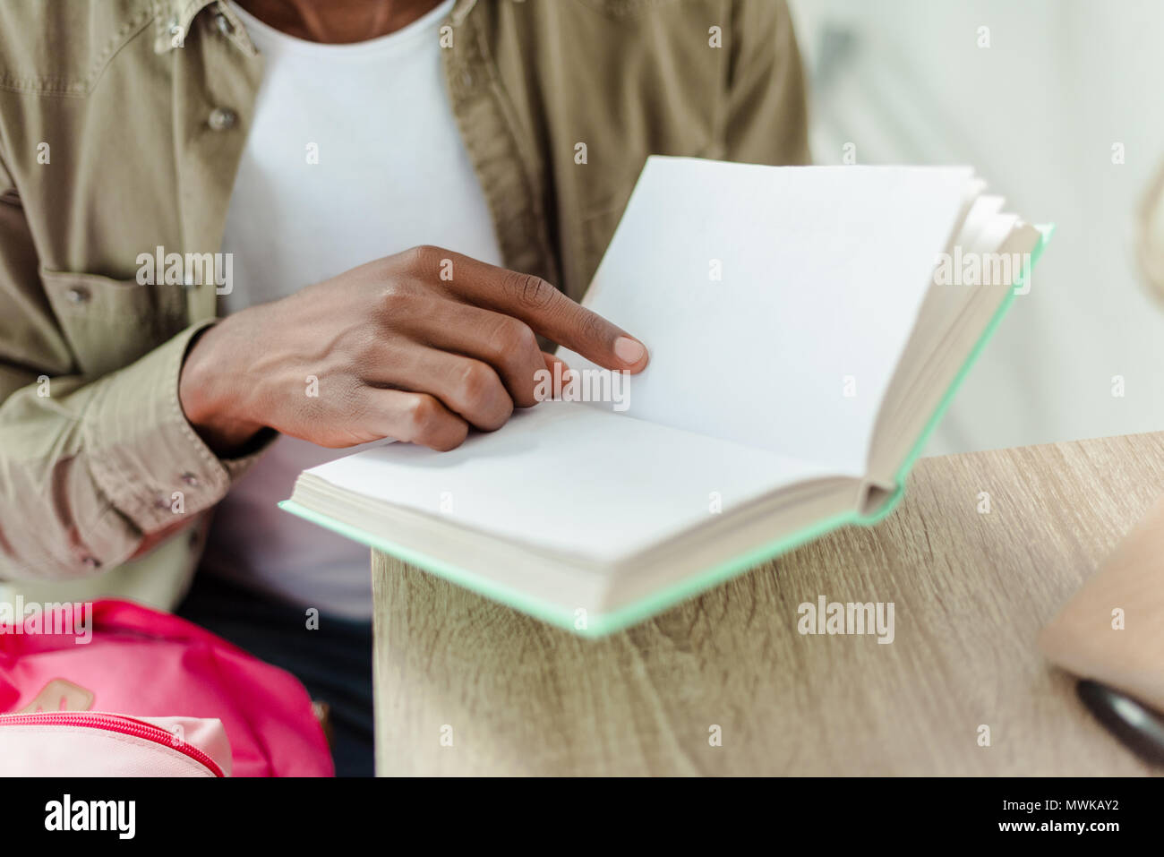 Cropped shot of a man pointing his finger at an open book page Stock ...