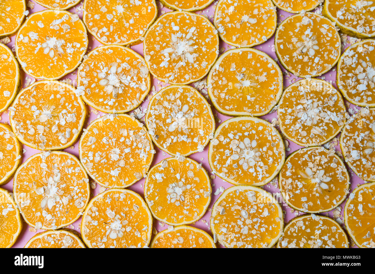 Beautiful texture of sliced orange with oat flakes on pink background ...