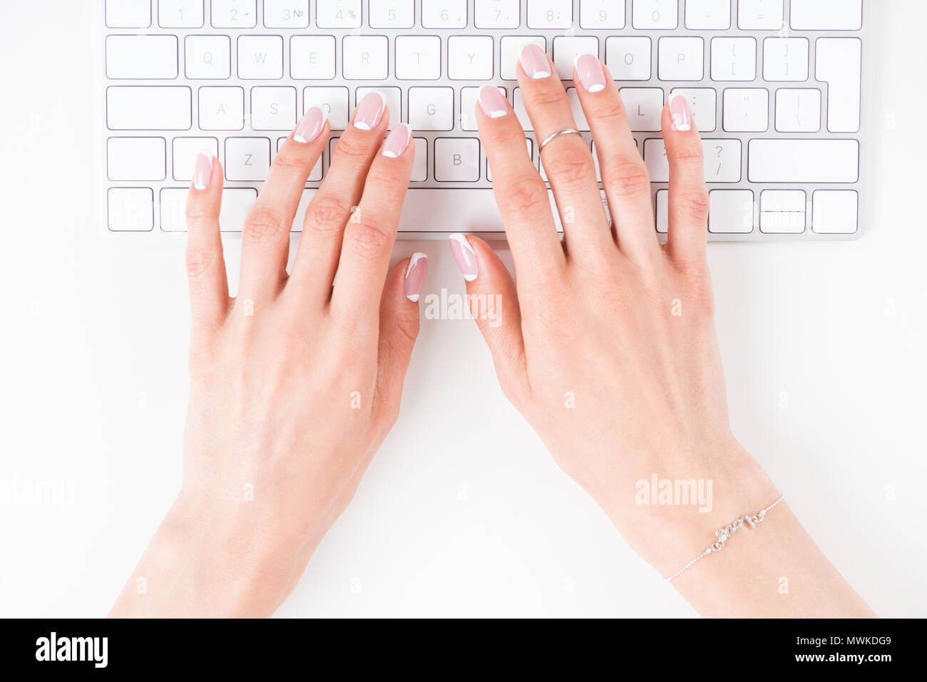 top view of female hands with beautiful manicure typing on keyboard ...