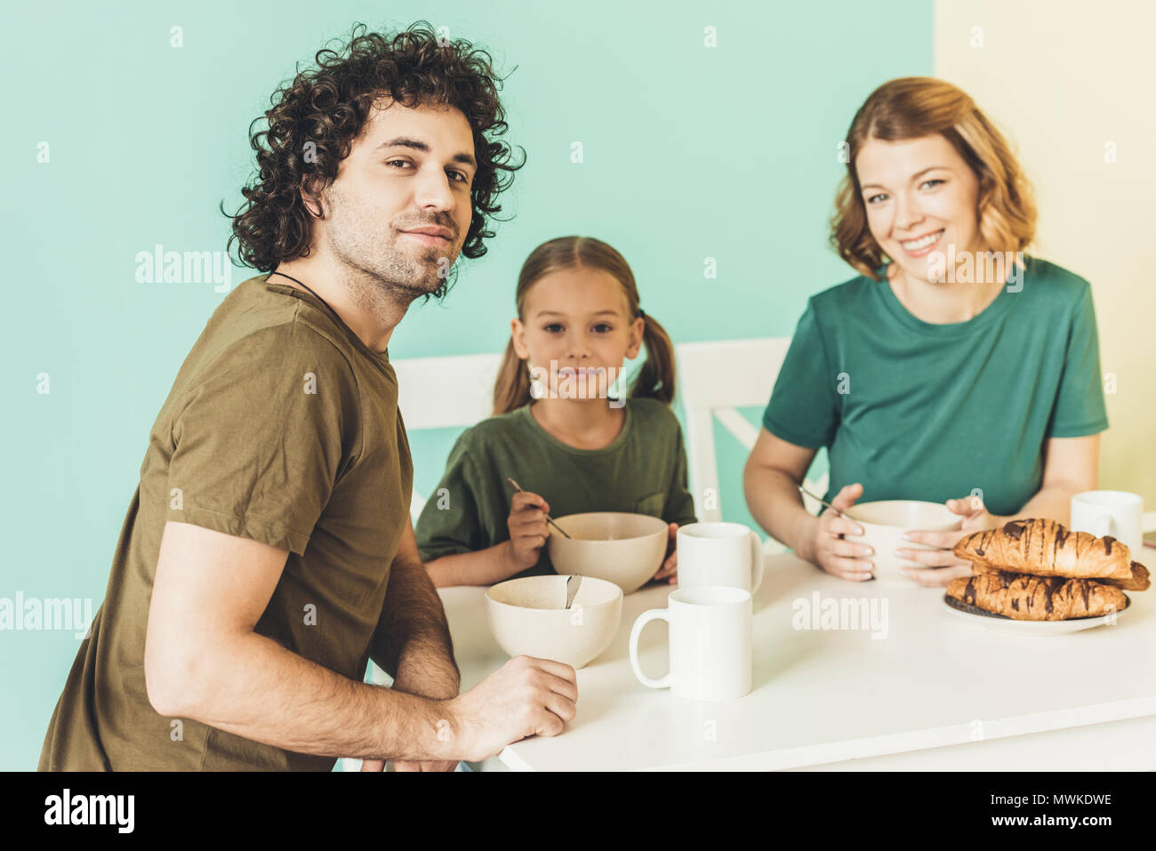 happy family eating breakfast together and smiling at camera Stock ...