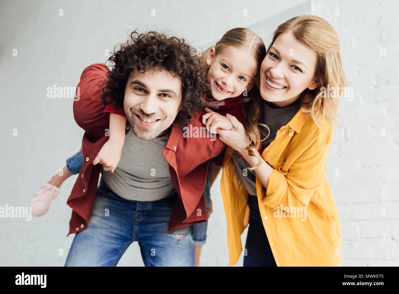 happy family with one child having fun together and smiling at camera ...