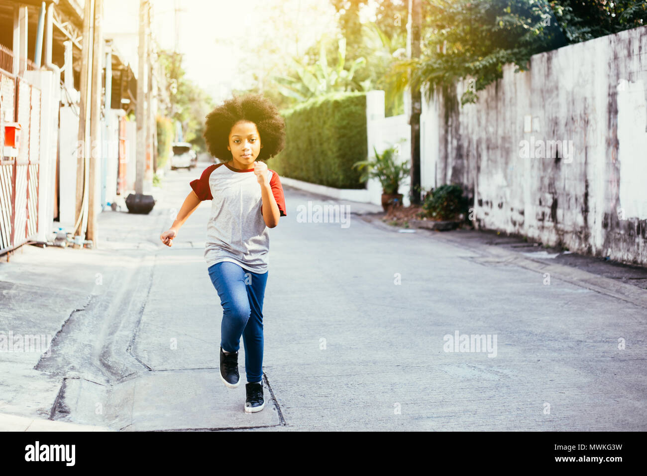 African American kid running on the street in urban city Stock Photo ...