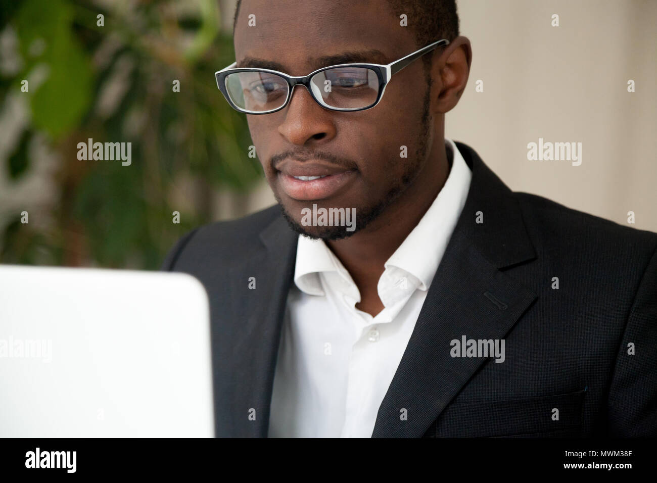 Focused African American CEO looking at laptop screen reading ne Stock ...