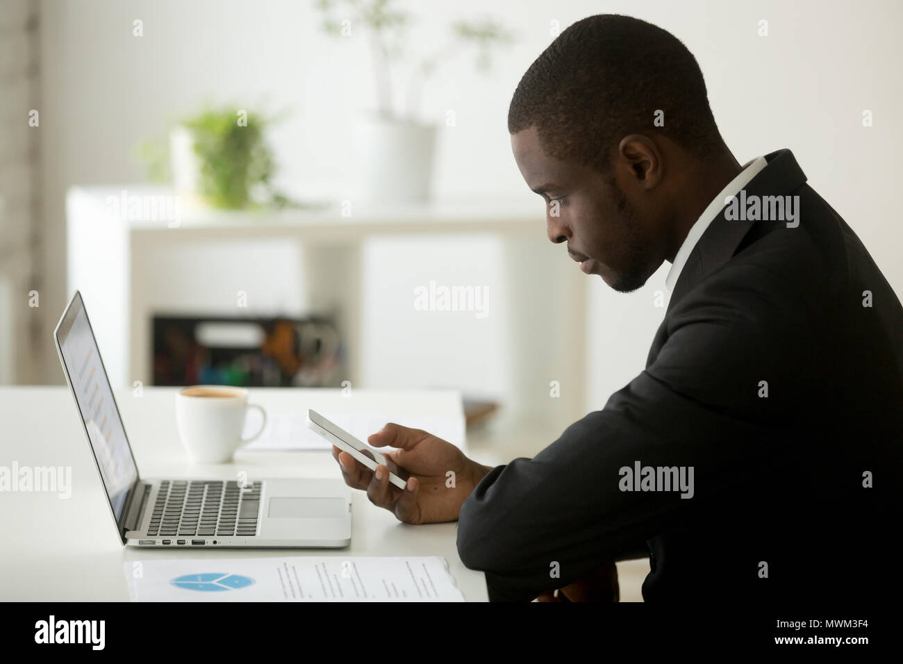 Focused African American checking phone email in office Stock Photo - Alamy