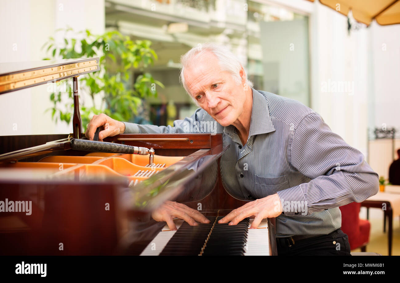 Elderly music instrument technician tuning a piano keyboard Stock Photo ...