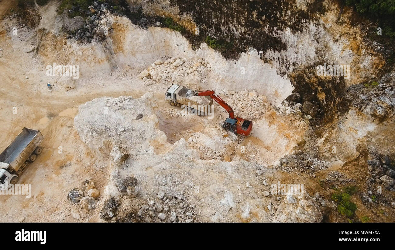 Excavator loads the truck in a limestone quarry. Aerial view wheel ...