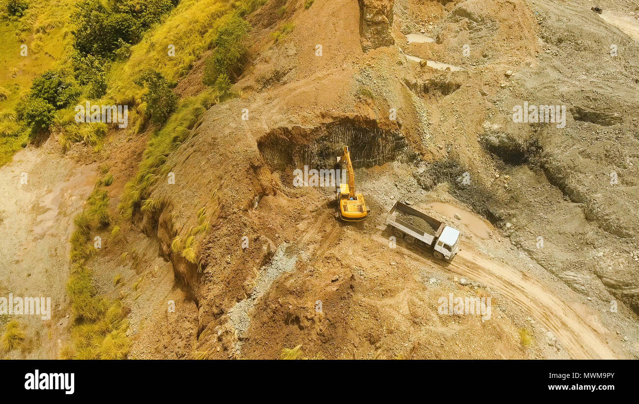 Excavator loads the truck in quarry. Aerial view wheel loader excavator ...