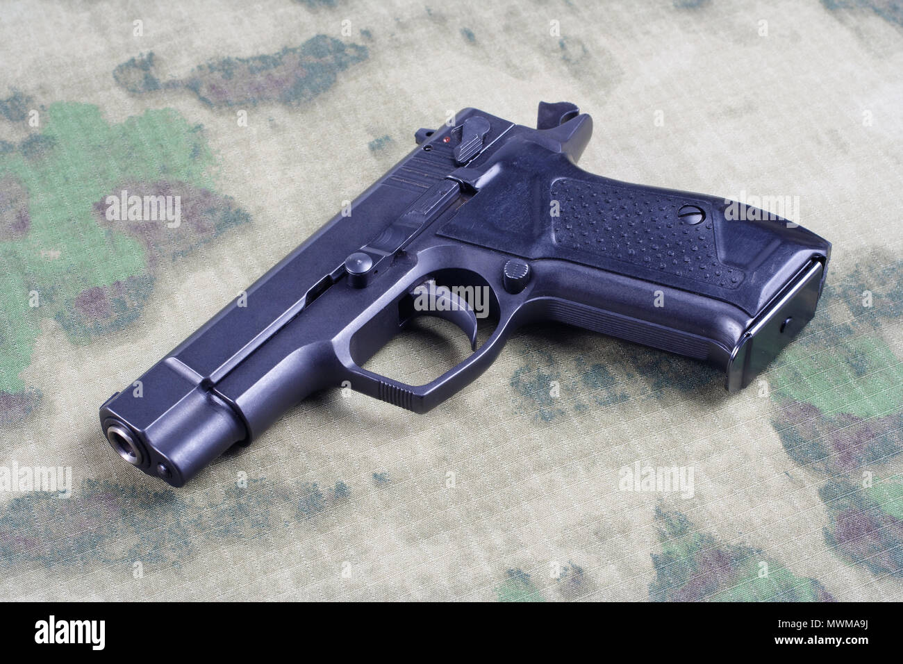 modern handgun on camouflage background Stock Photo - Alamy