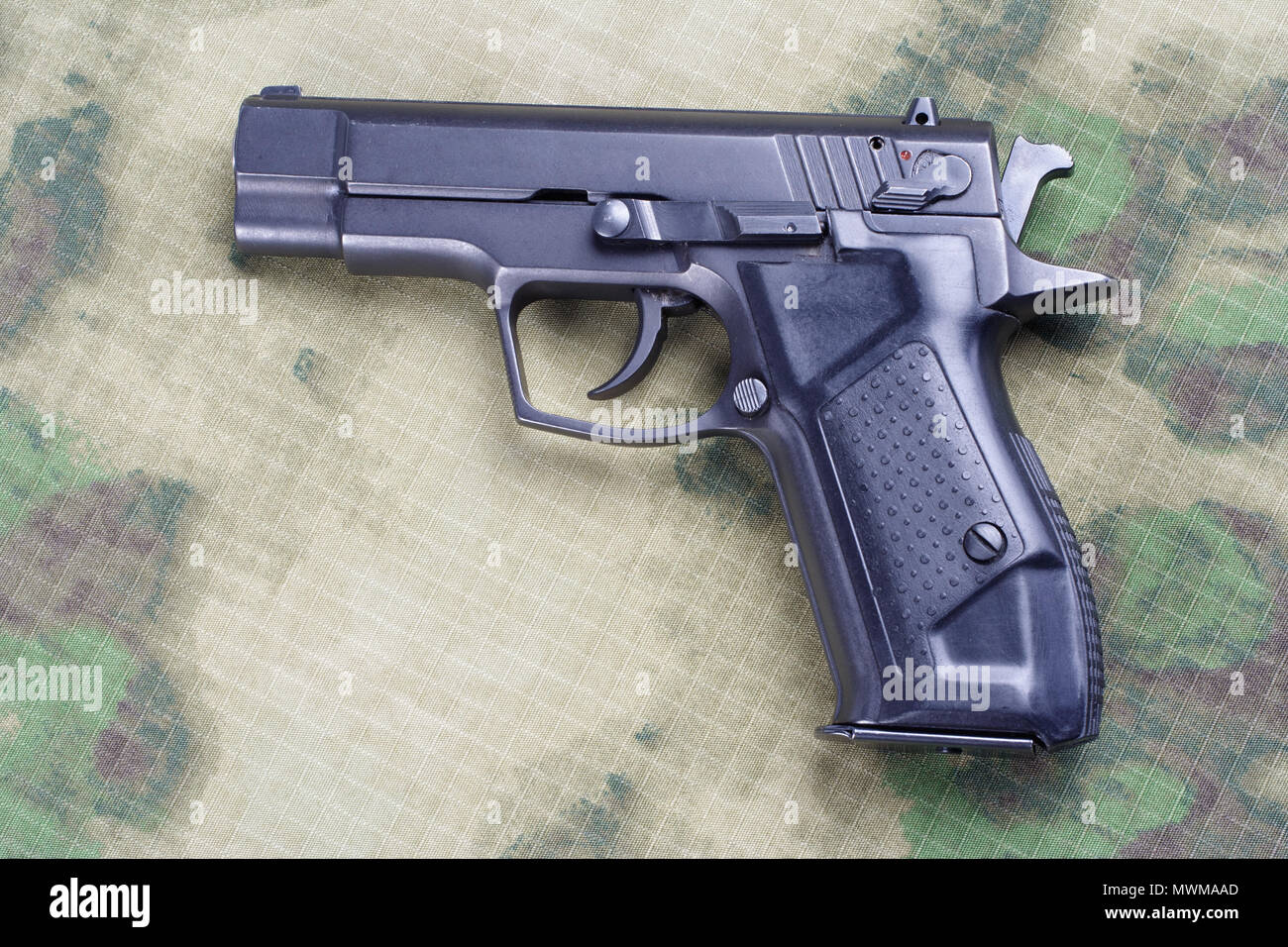modern handgun on camouflage background Stock Photo - Alamy