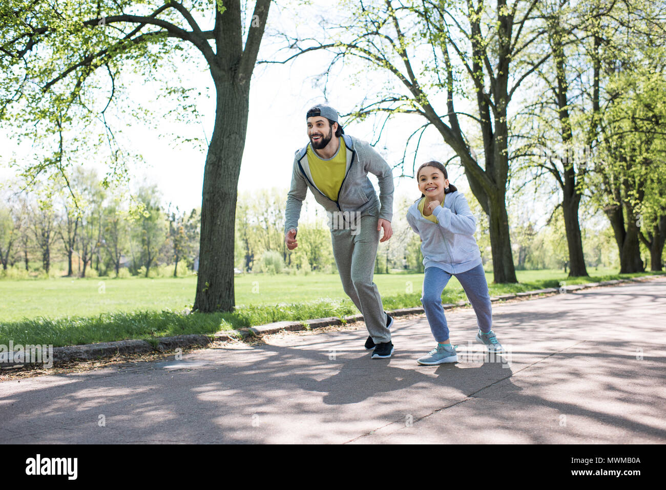 happy father and daughter running on path in park Stock Photo - Alamy