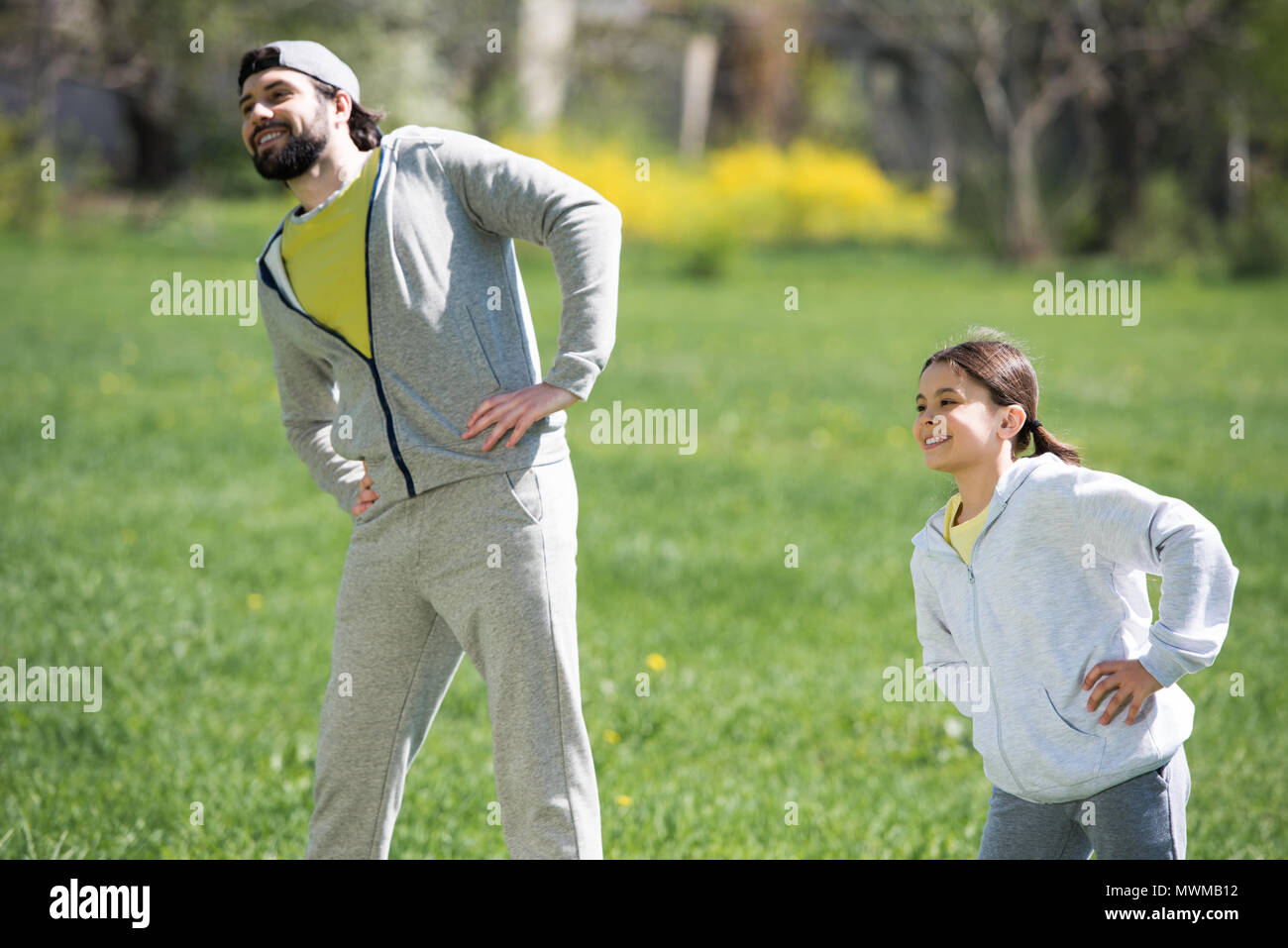 happy father and daughter doing physical exercise in park Stock Photo ...