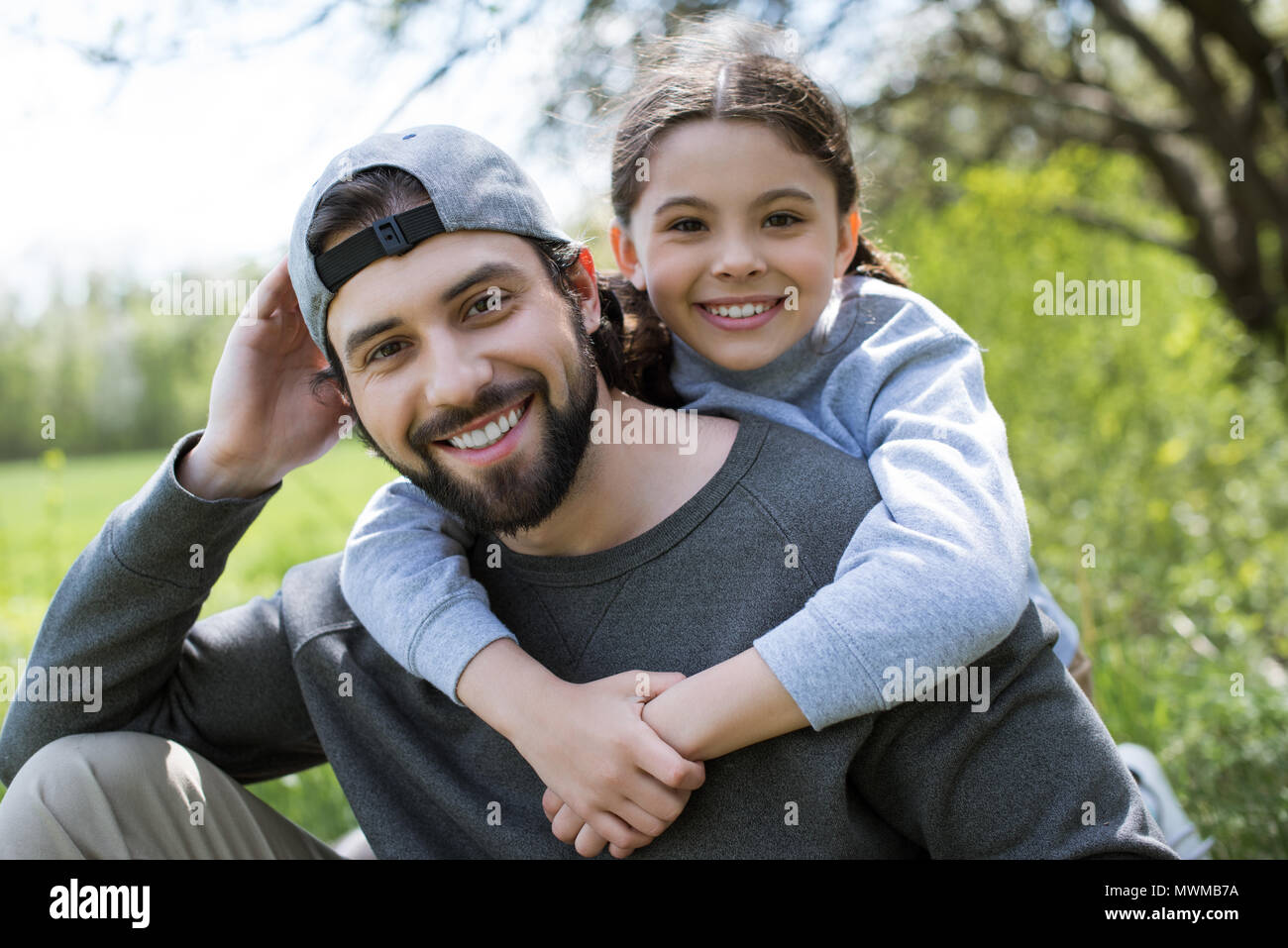 little child embracing smiling father in park Stock Photo - Alamy
