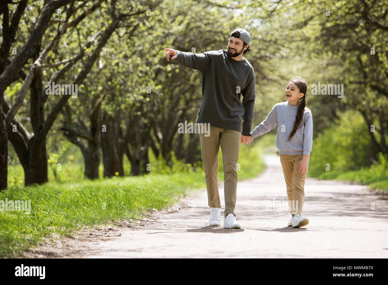 father pointing by finger to daughter in park Stock Photo - Alamy