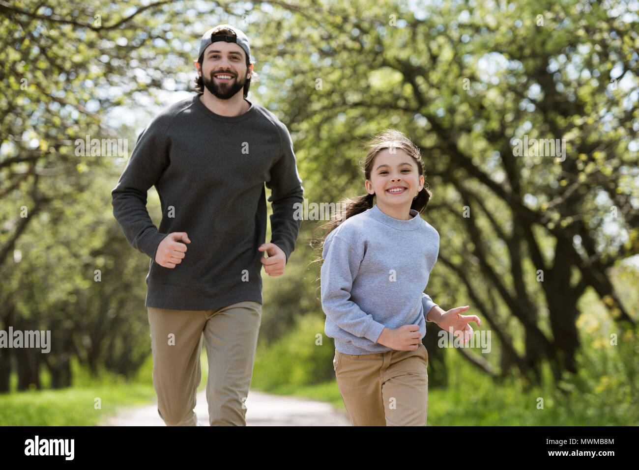 smiling father and daughter running in park Stock Photo - Alamy