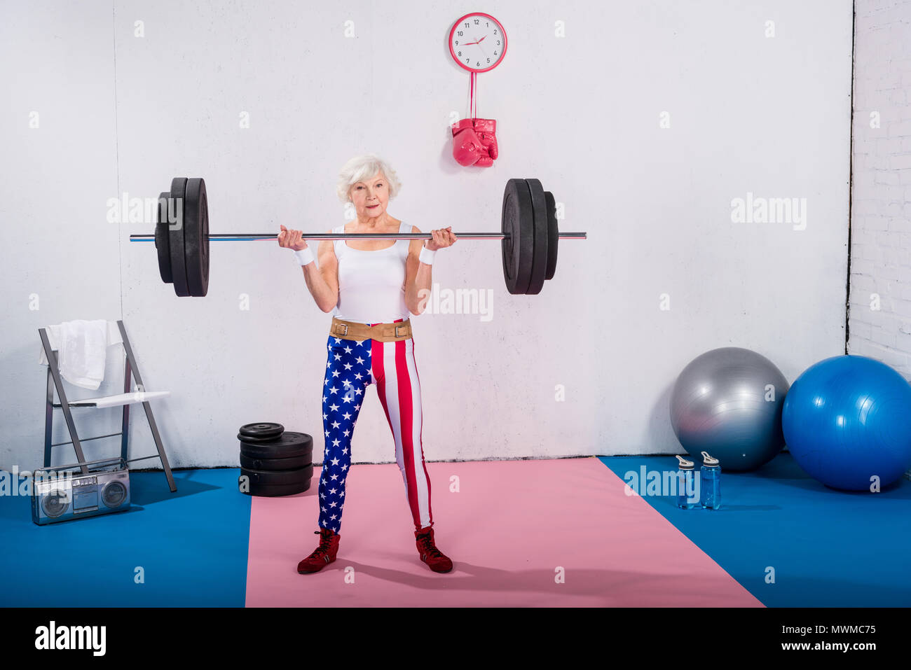 sporty senior lady lifting barbell and looking at camera Stock Photo ...