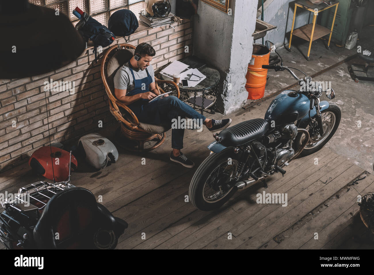 mechanic using digital tablet in repair shop with motorbike Stock Photo ...