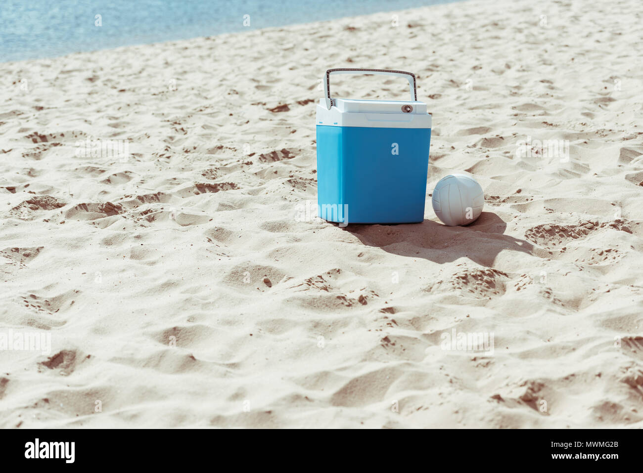 blue cooler box and volleyball ball on sandy beach Stock Photo - Alamy
