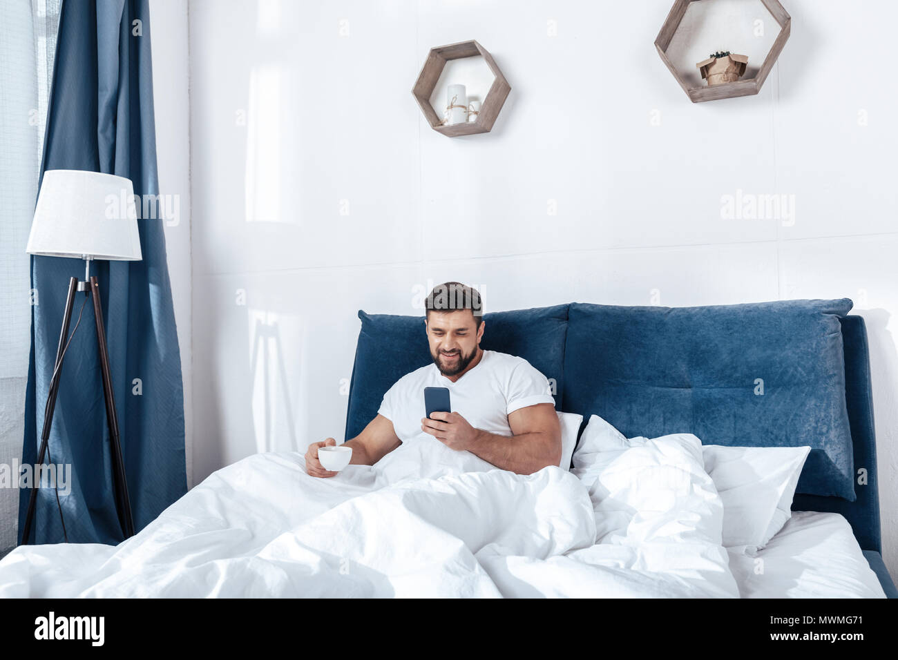 Guy smartphone relaxing in bed hi-res stock photography and images - Alamy