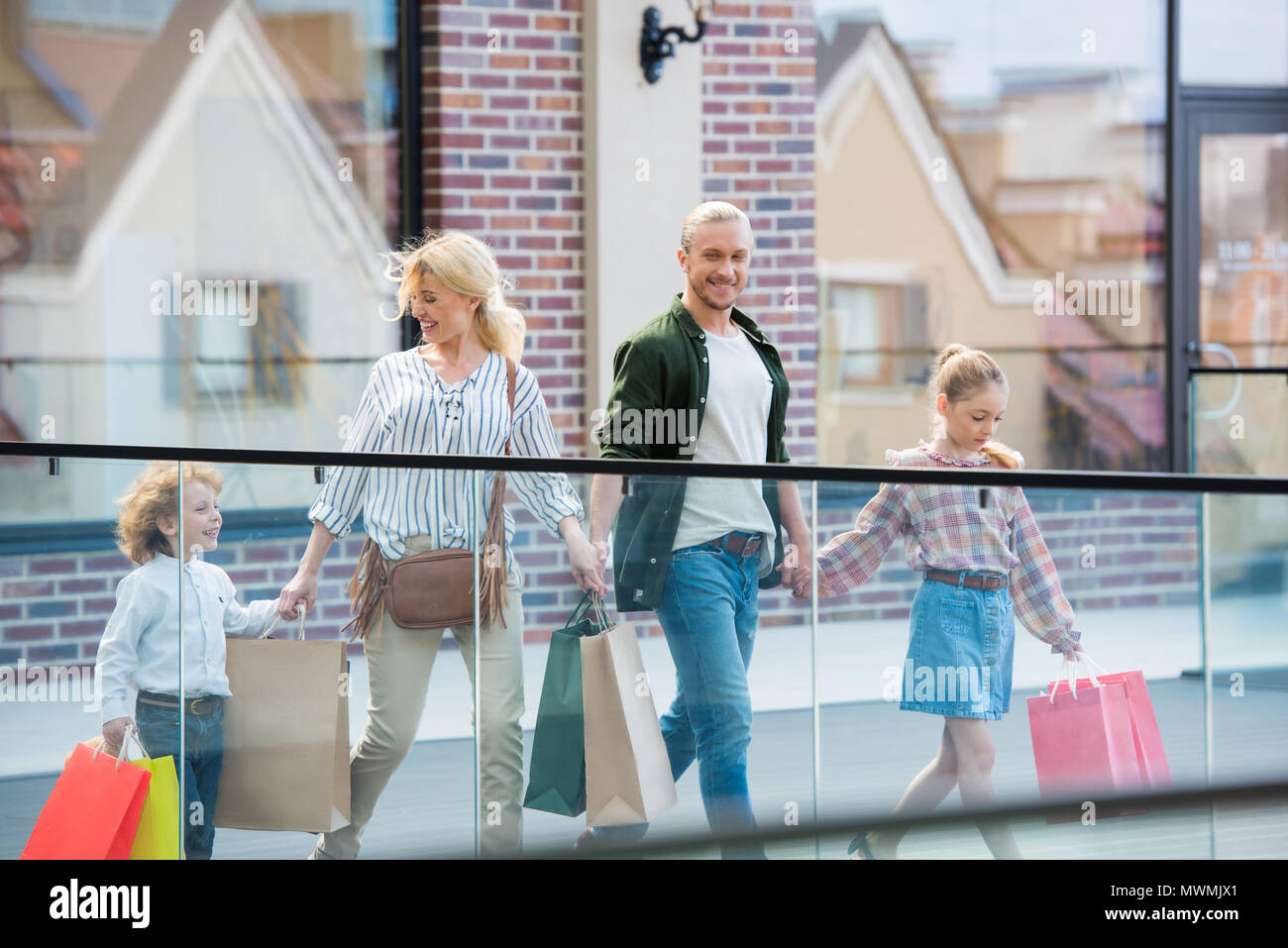 parents and little kids walking together in shopping mall Stock Photo ...
