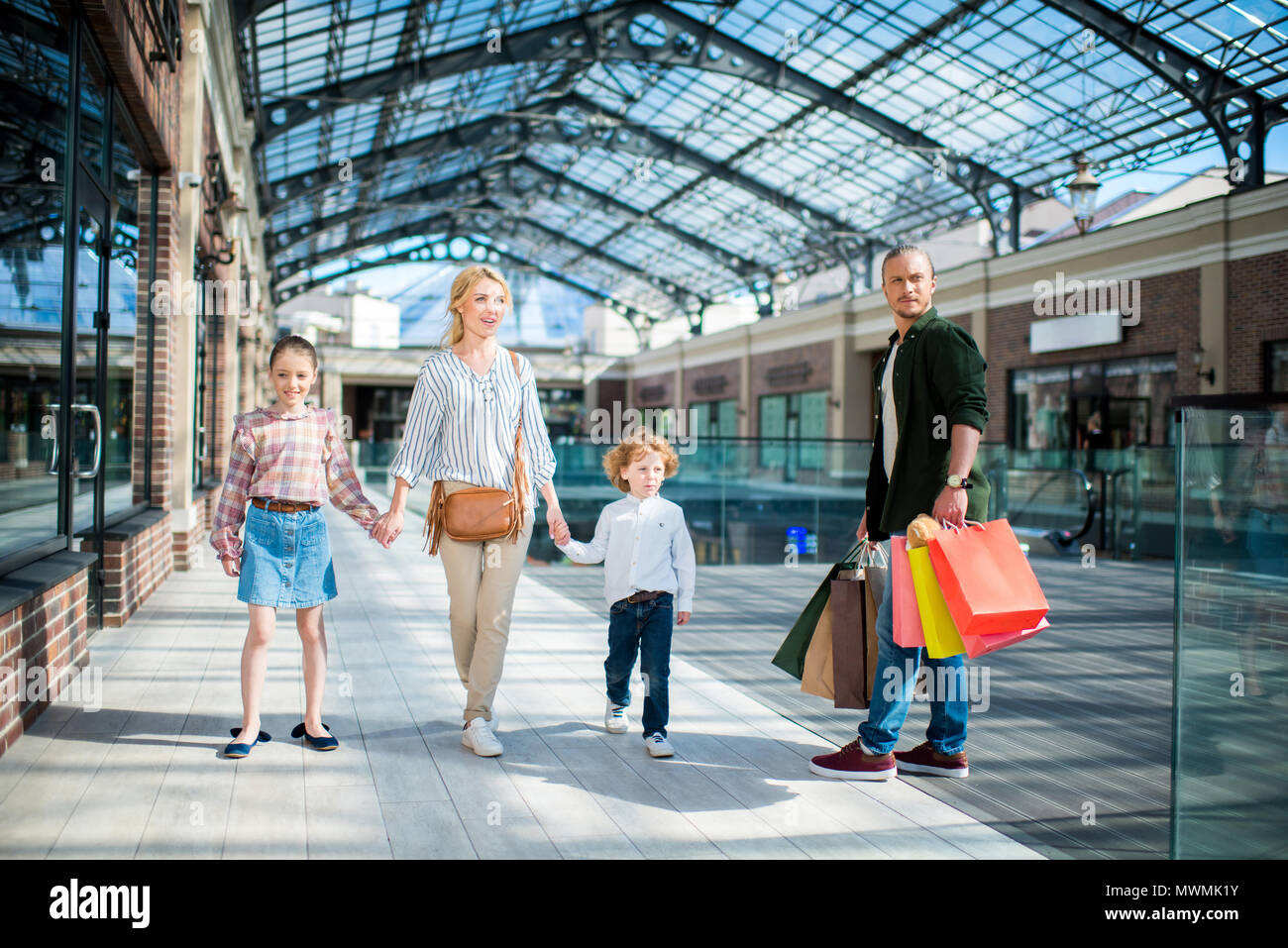 parents and little kids walking together in shopping mall Stock Photo ...