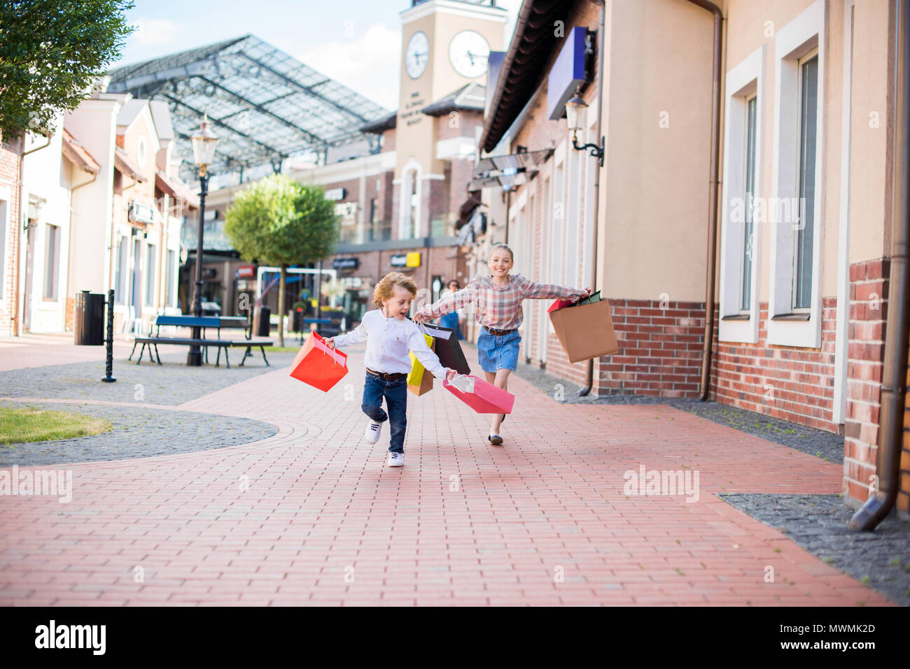 Happy children running with shopping bags in hands on street Stock ...