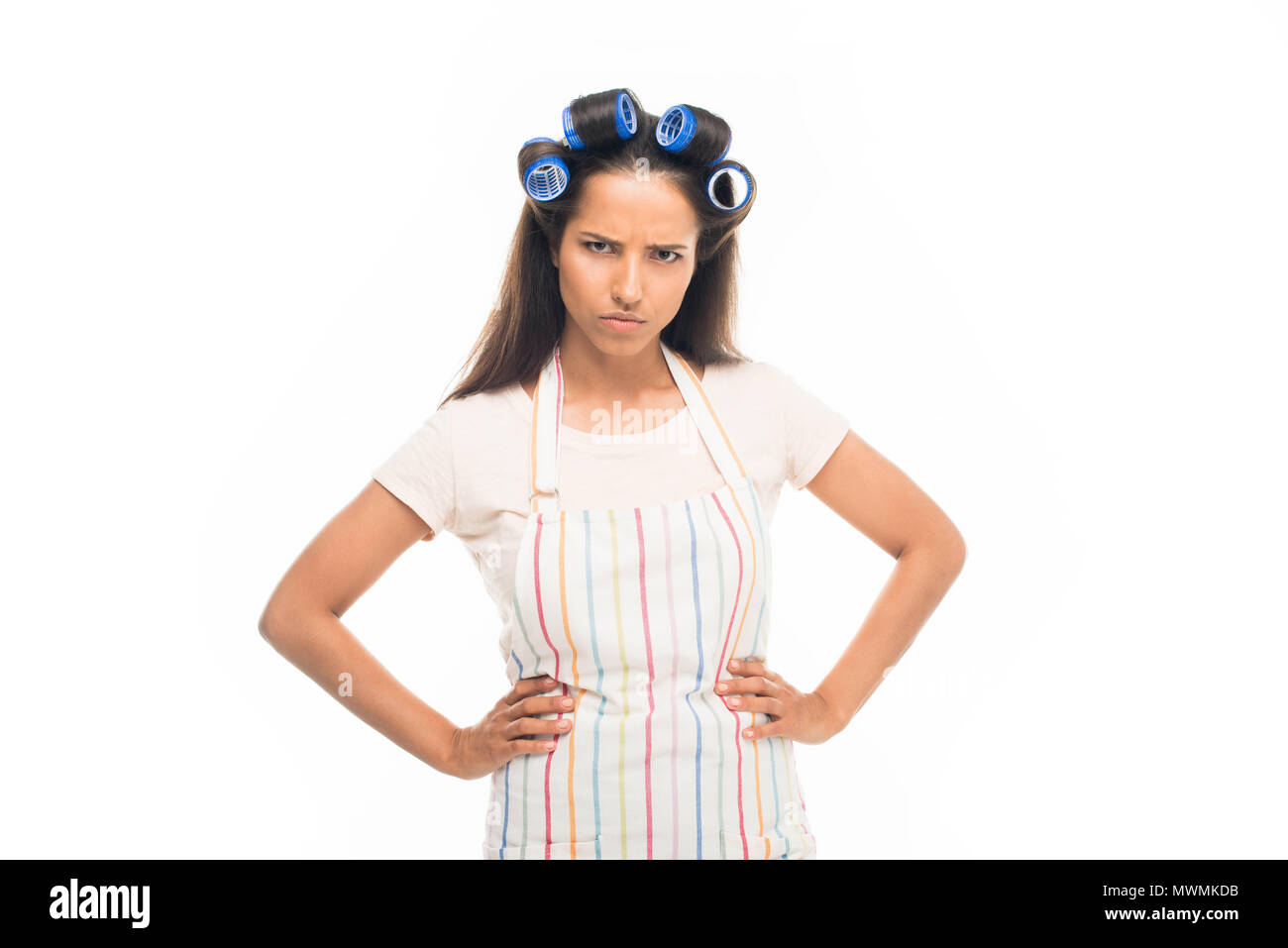 Angry Housewife With Curlers Standing With Hands On Hips Isolated On