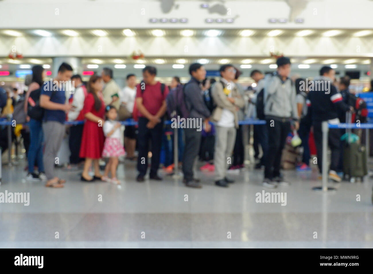 Blurred defocused image of passengers check in at the check-in counter ...
