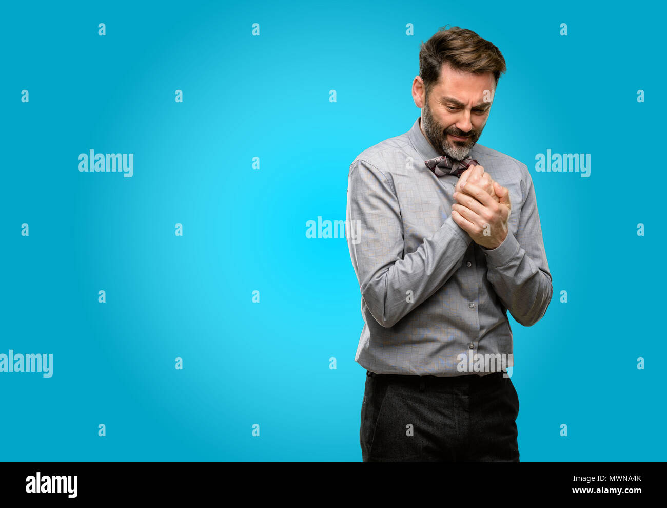 Middle age man, with beard and bow tie crying depressed full of sadness ...