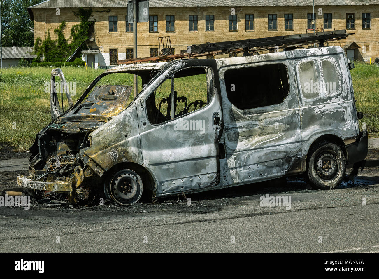 Fully burned minivan on the city road Stock Photo - Alamy