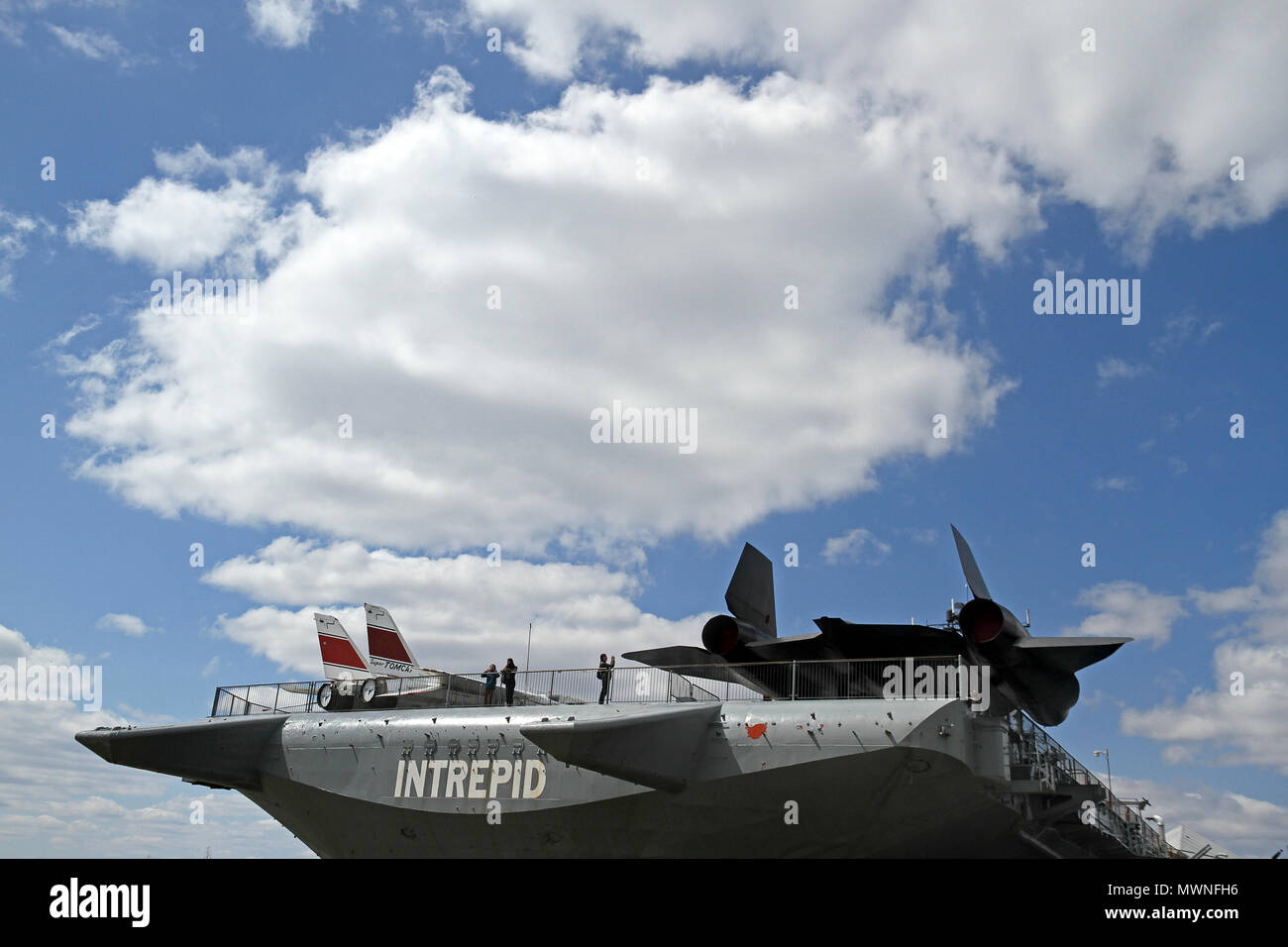 People stand on the deck of the aircraft carrier USS Intrepid, part of ...