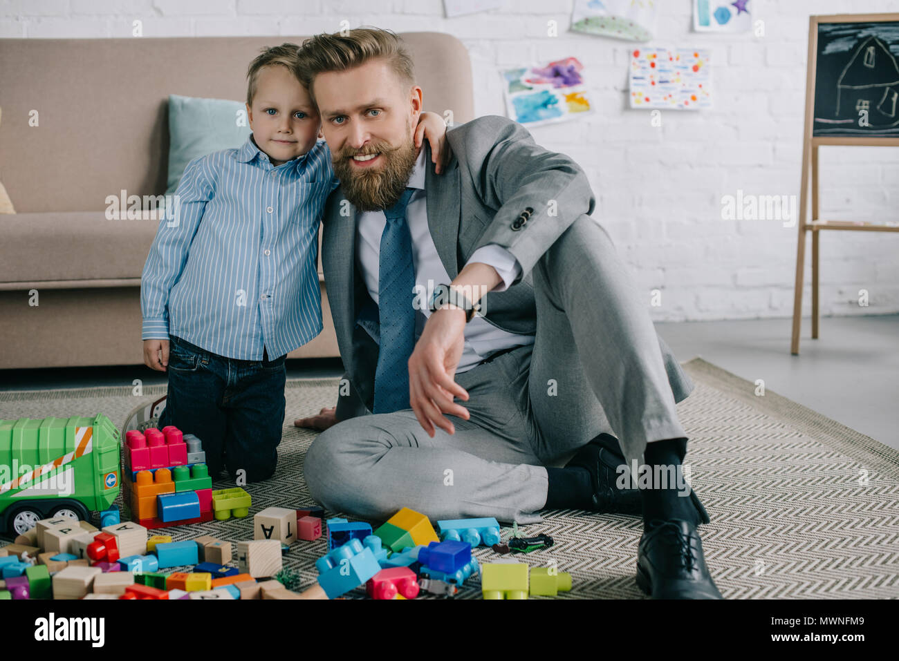 little boy hugging smiling father in business suit at home, work and ...