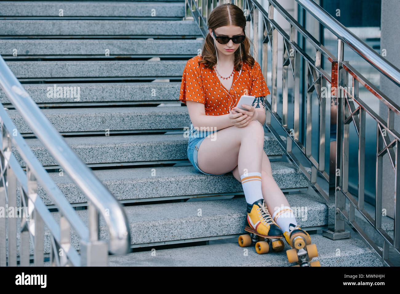 beautiful girl in sunglasses and roller skates sitting on stairs and ...