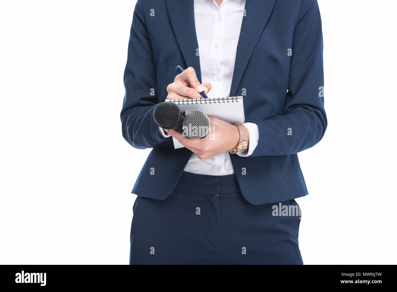 cropped view of female journalist in suit with microphones writing in ...