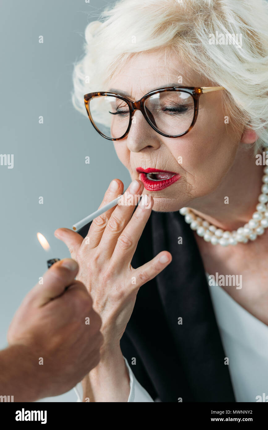 beautiful senior lady with pearl necklace smoking cigarette, isolated ...
