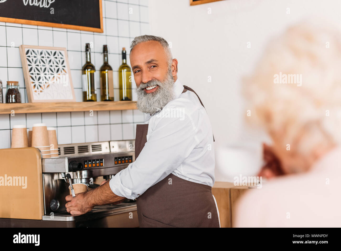 selective focus of smiling senior barista making coffee in cafe Stock ...