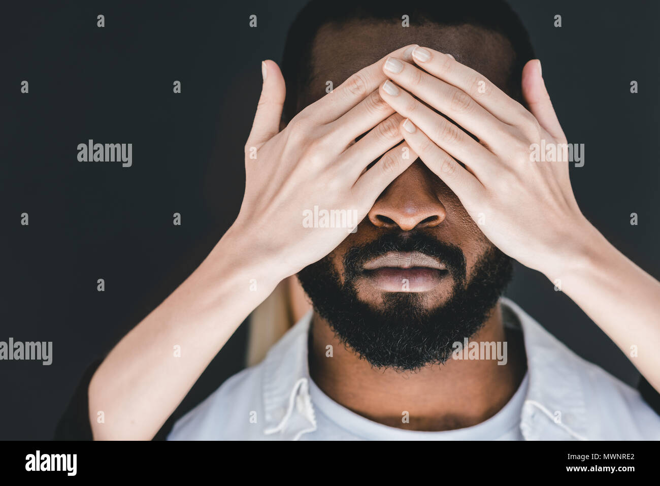cropped image of girlfriend closing african american boyfriend eyes ...