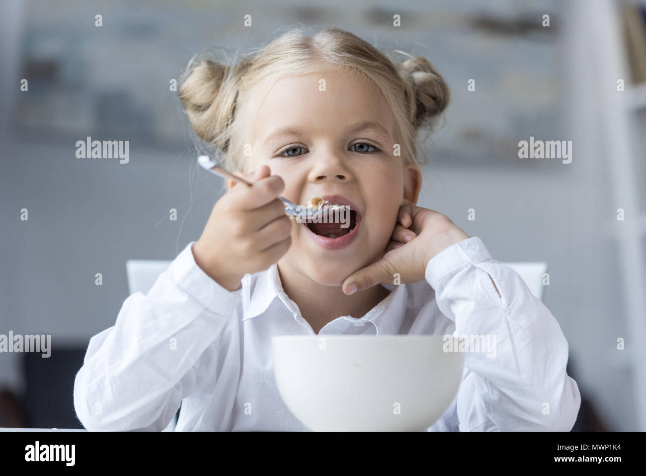 adorable little girl eating corn flakes for breakfast Stock Photo - Alamy
