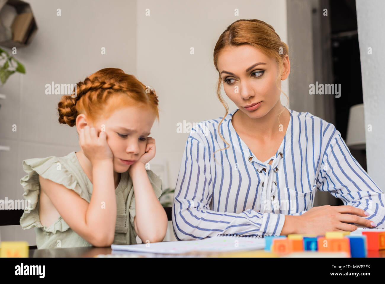 beautiful young mother looking sceptical on sad little daughter Stock ...