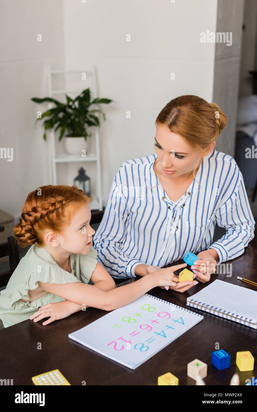 beautiful concentrated mother and daughter learning math at home Stock ...
