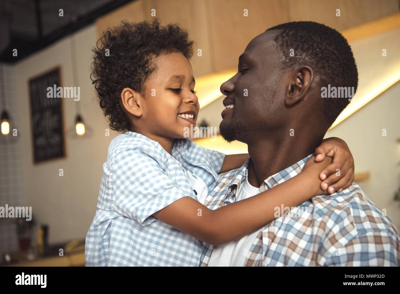 happy african american father and child hugging and smiling each other ...