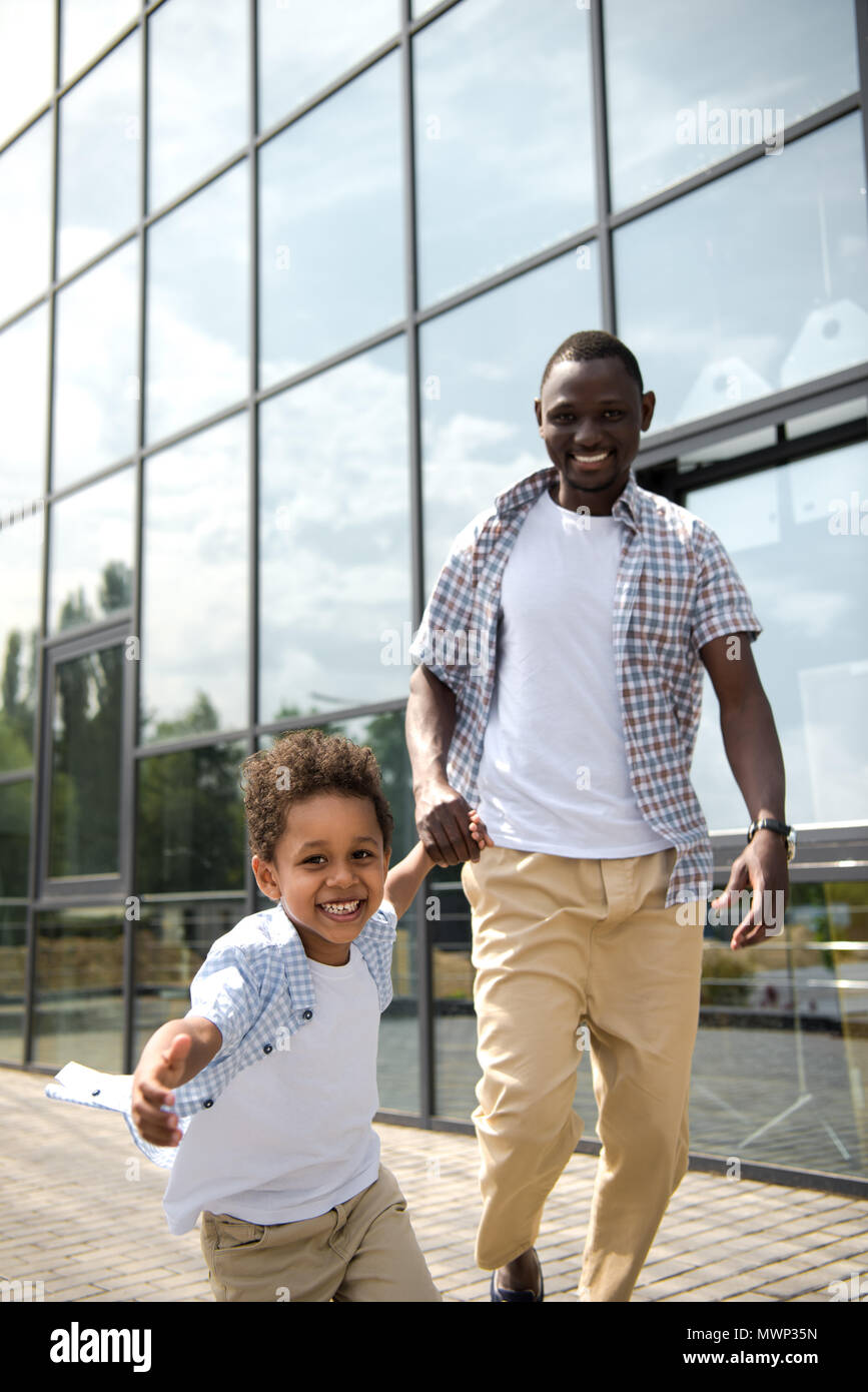 happy african american father and son holding hands and running Stock ...