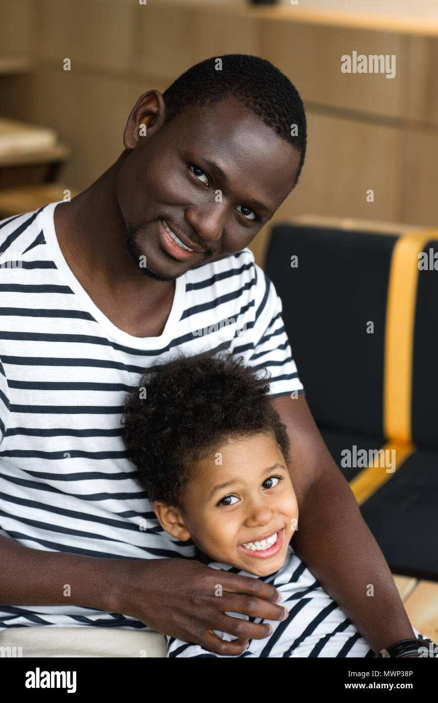 Happy African American Father And Son Hugging And Smiling At Camera