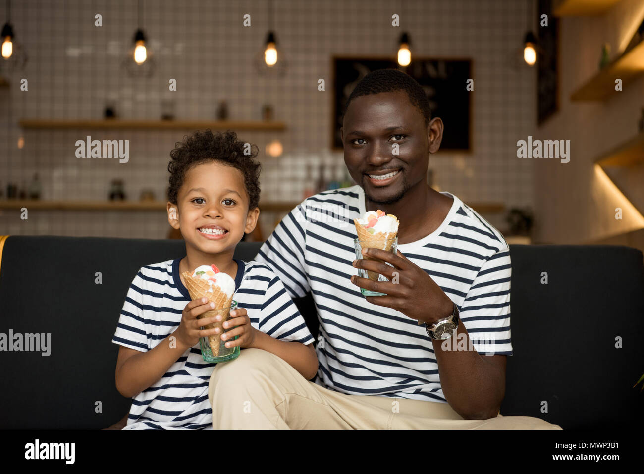 Happy African American Father And Son Eating Ice Cream And Smiling At