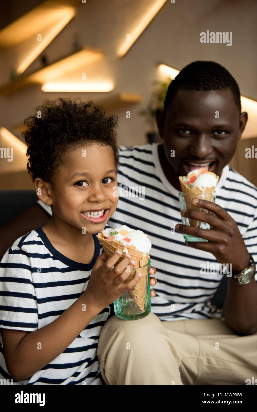 Happy African American Father And Son Eating Ice Cream And Smiling At