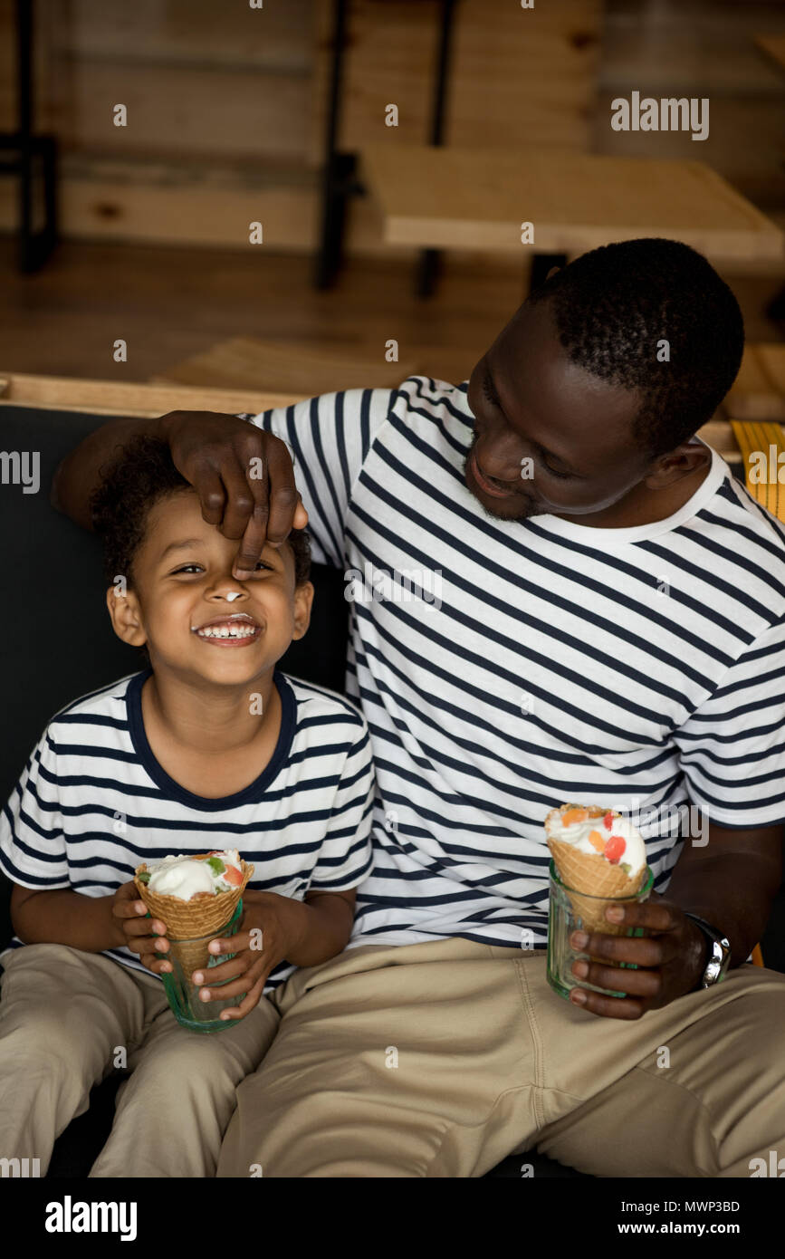 Happy African American Father And Son Eating Ice Cream And Having Fun