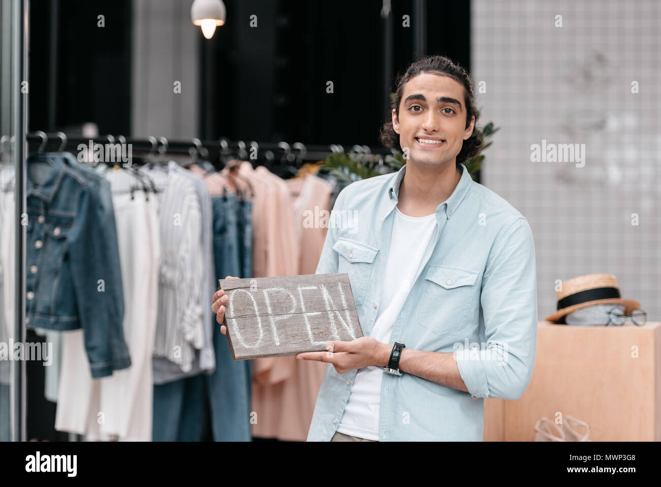handsome young shop owner holding open sign and smiling at camera Stock ...