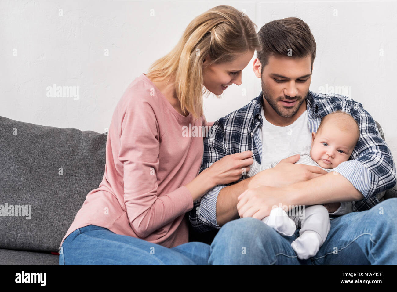 young smiling parents holding ther cute baby boy Stock Photo - Alamy